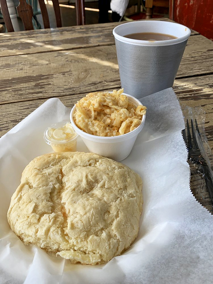 A perfect biscuit, hashbrown casserole, and coffee &ndash; the holy trinity of morning salvation on a weathered wooden table.