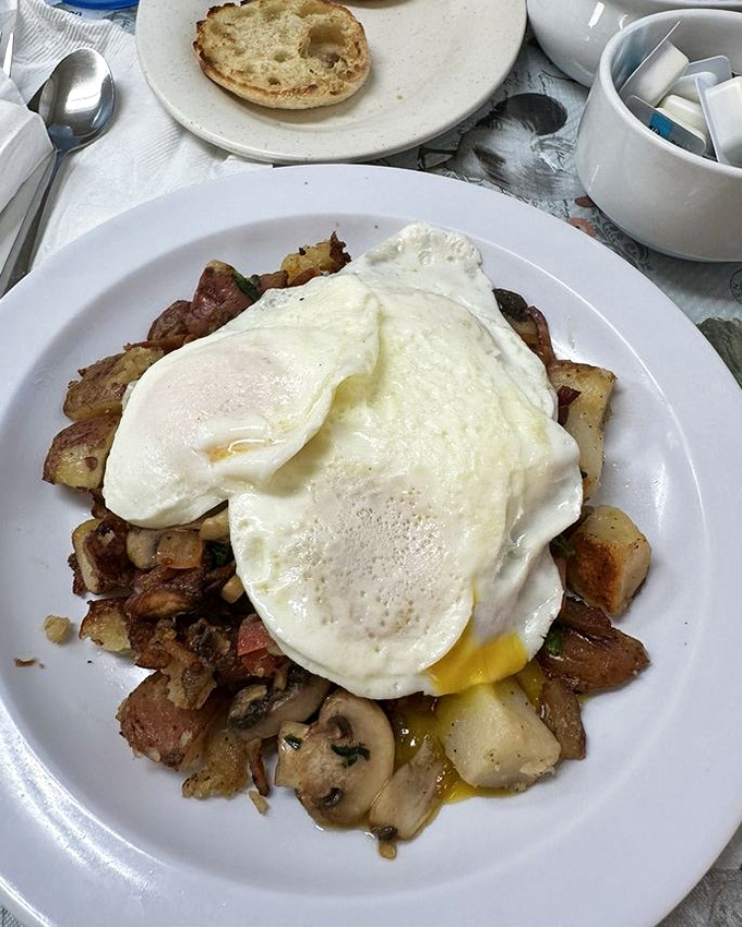 Eggs perched atop a mountain of potatoes and mushrooms &ndash; proof that sometimes the messiest breakfasts are life's greatest pleasures.