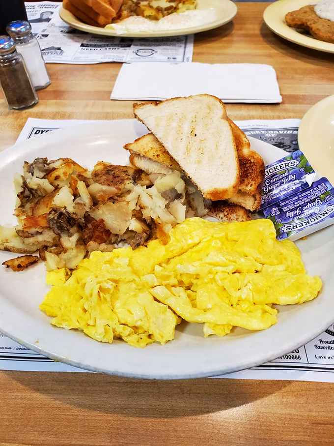 The breakfast trinity: perfectly scrambled eggs, crispy home fries, and toast—proof that simplicity, when done right, is culinary genius.
