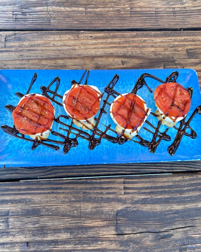 These aren't just tomatoes with a fancy drizzle&mdash;they're little red flavor bombs on a sea of blue, waiting to transport you to Mediterranean shores.