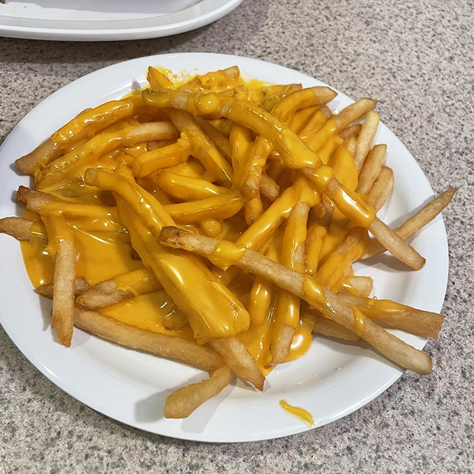 These cheese fries aren't just a side dish&mdash;they're the main event, wearing their golden cheese sauce like a royal robe.