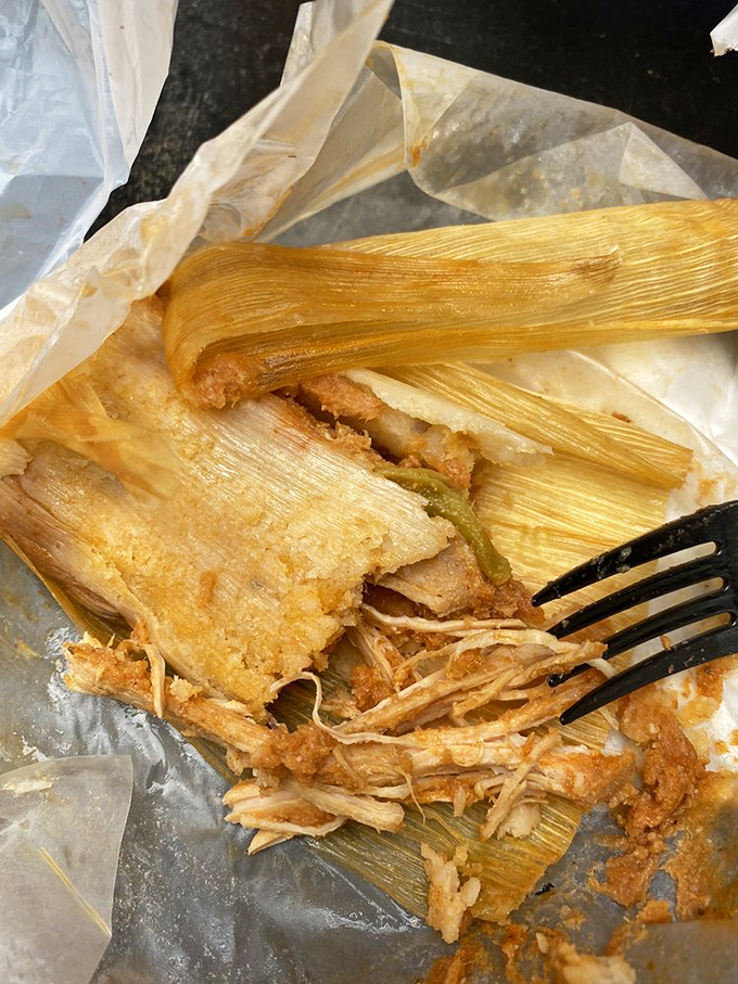 Unwrapped and ready for its close-up, this tamale reveals tender chicken swimming in golden goodness.