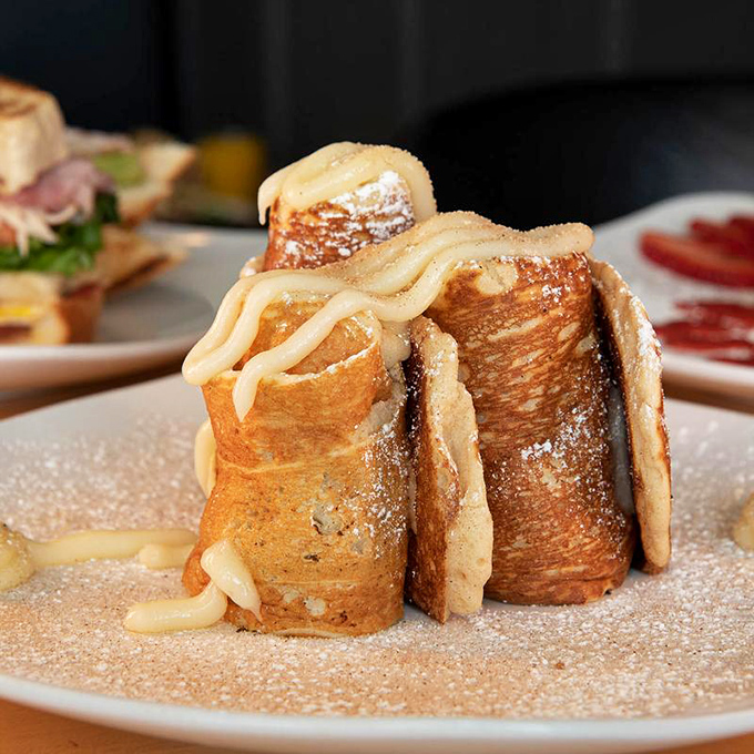 Cinnamon roll pancakes, dusted with sweetness and drizzled in luscious cream cheese glaze &mdash; a dreamy treat perfect any time of day.
