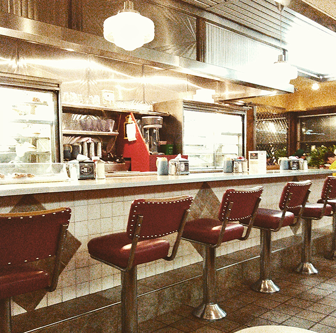 The counter seats&mdash;where solo diners become part of the diner's story, watching short-order ballet performed with spatulas and sizzling grills.