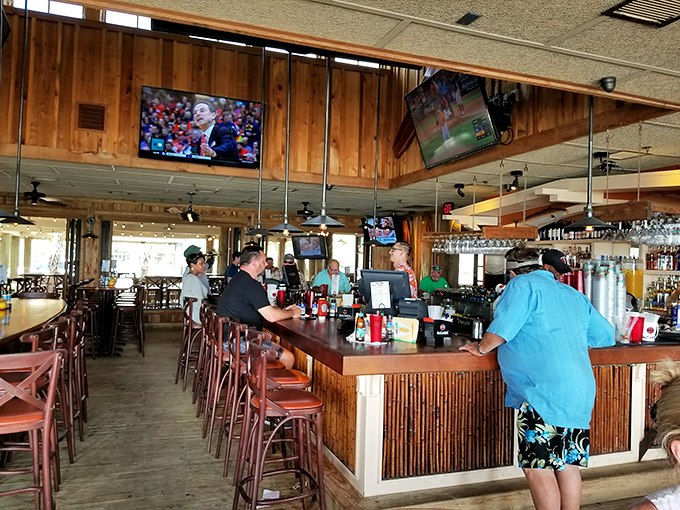 The bar area: where strangers become friends and "just one more" becomes the evening's mantra. Sports on TV, paradise out the window.