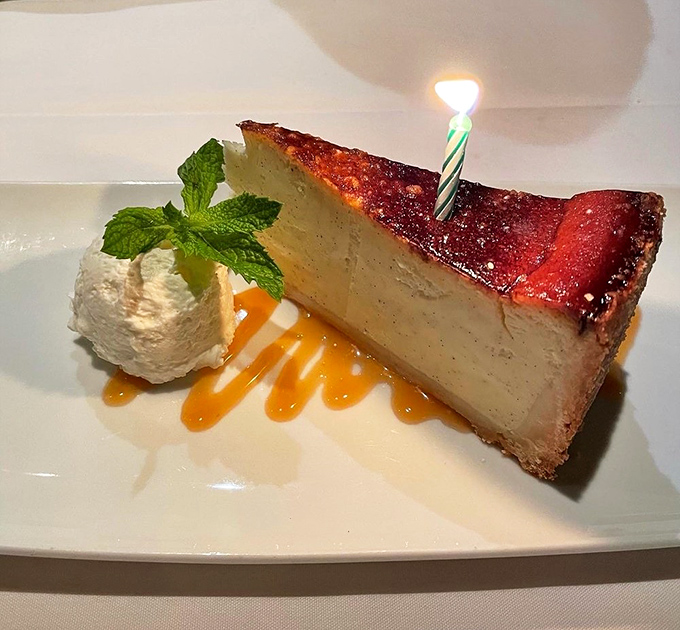 Birthday candle meets culinary artistry on this slice of cheesecake that's dressed to impress, with caramel drizzles that belong in the sauce hall of fame.