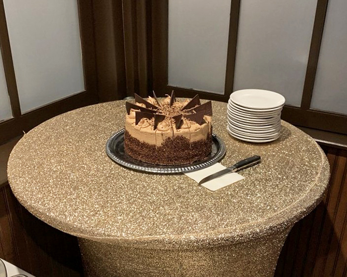 Chocolate cake that doesn't just sit on the plate – it commands attention with its dramatic chocolate shards and perfect frosting-to-cake ratio.