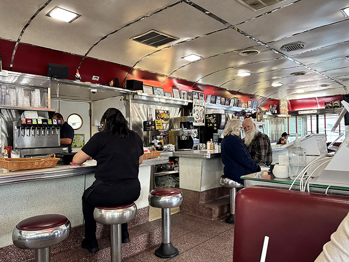 The classic diner counter where strangers become friends over shared plates and endless coffee refills.