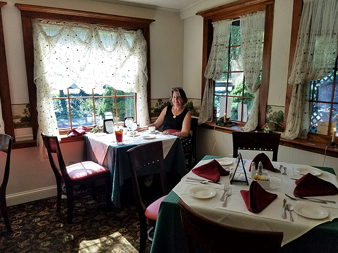 Sunlight streams through lace curtains, turning an ordinary lunch into a moment worth remembering in this cozy corner table.
