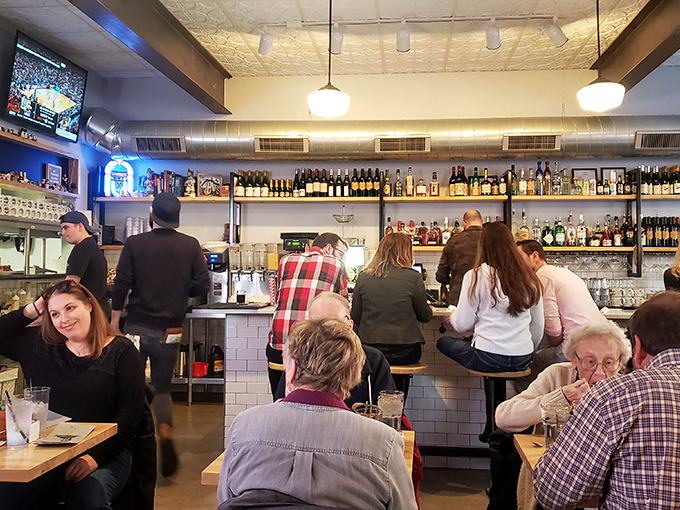 A bustling bar scene where strangers become friends over shared plates and the universal language of "you've got to try this."