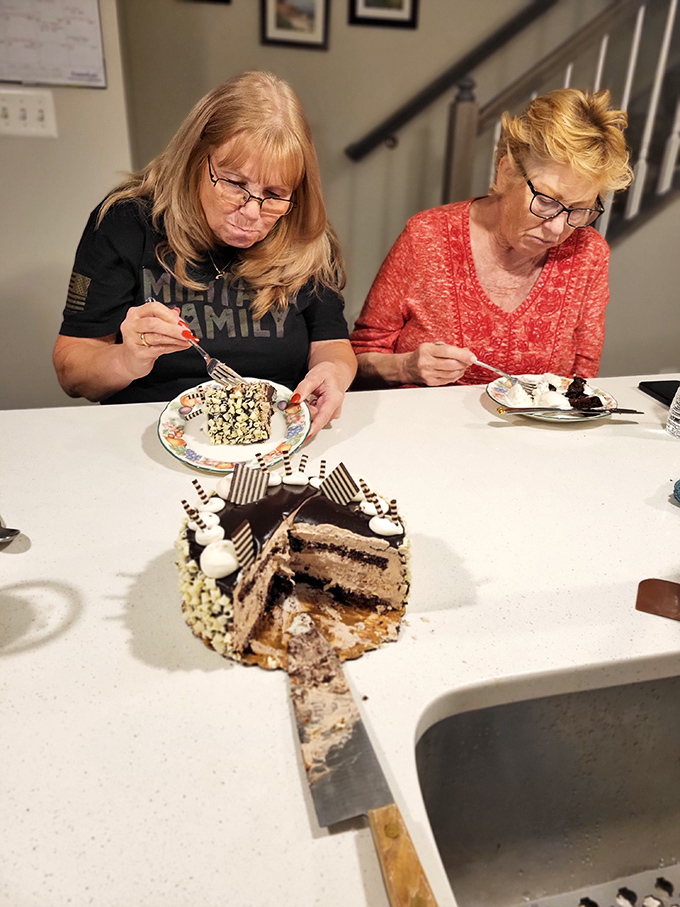 Two dessert enthusiasts facing the ultimate challenge: how to savor every magnificent layer of that chocolate masterpiece without rushing.