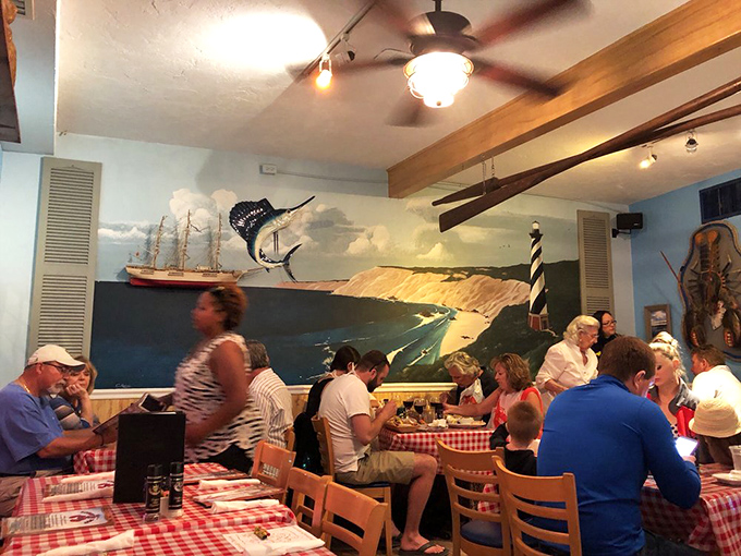 A coastal mural watches over diners like a painted window to the Atlantic, while checkered tablecloths keep the mood cheerfully unpretentious.
