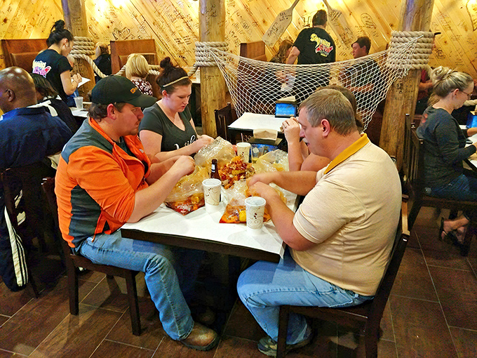 The universal language of seafood boils: heads bowed in concentration, hands busy with shells, conversation paused for the serious business of flavor extraction. 