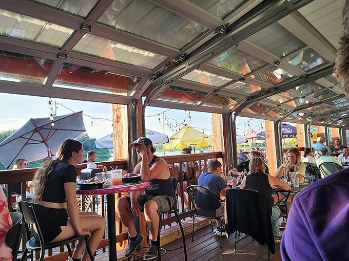 The outdoor dining area comes alive during warmer months, where river views and good company transform an ordinary meal into something worth remembering.