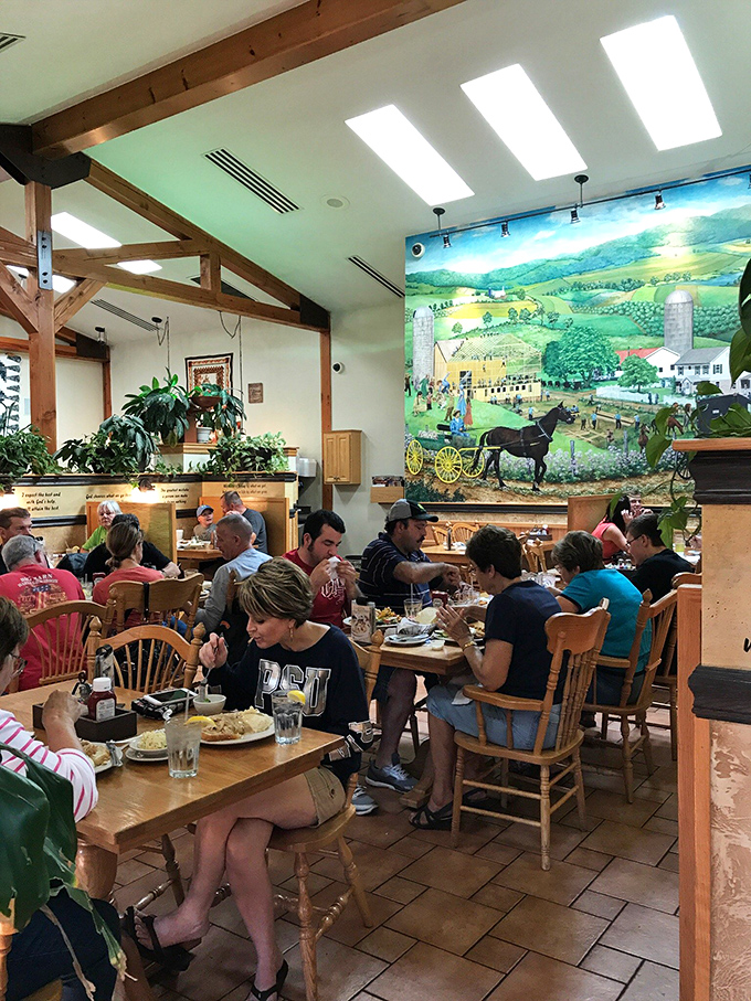 Where locals and travelers unite in the universal language of "please pass the syrup" under the watchful eye of Amish countryside art.