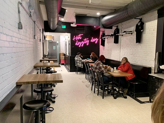 Community happens around these wooden tables, where strangers become friends united by the universal language of exceptional hot dogs.