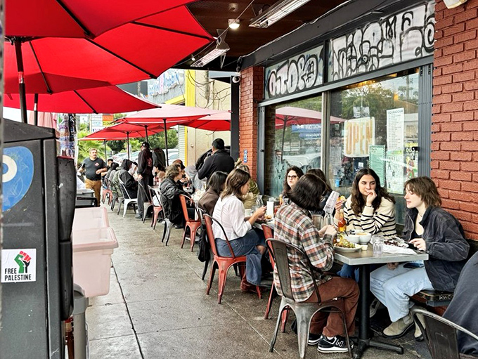 Red umbrellas creating the perfect breakfast sanctuary for people-watching and biscuit-savoring adventures.