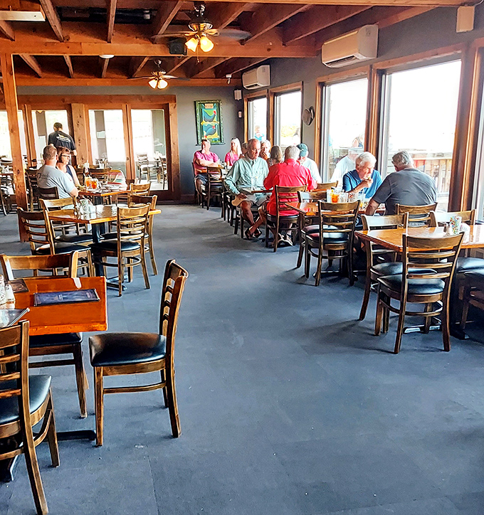 Regulars know the best conversations happen over seafood, where stories flow as freely as the waters visible through those windows.