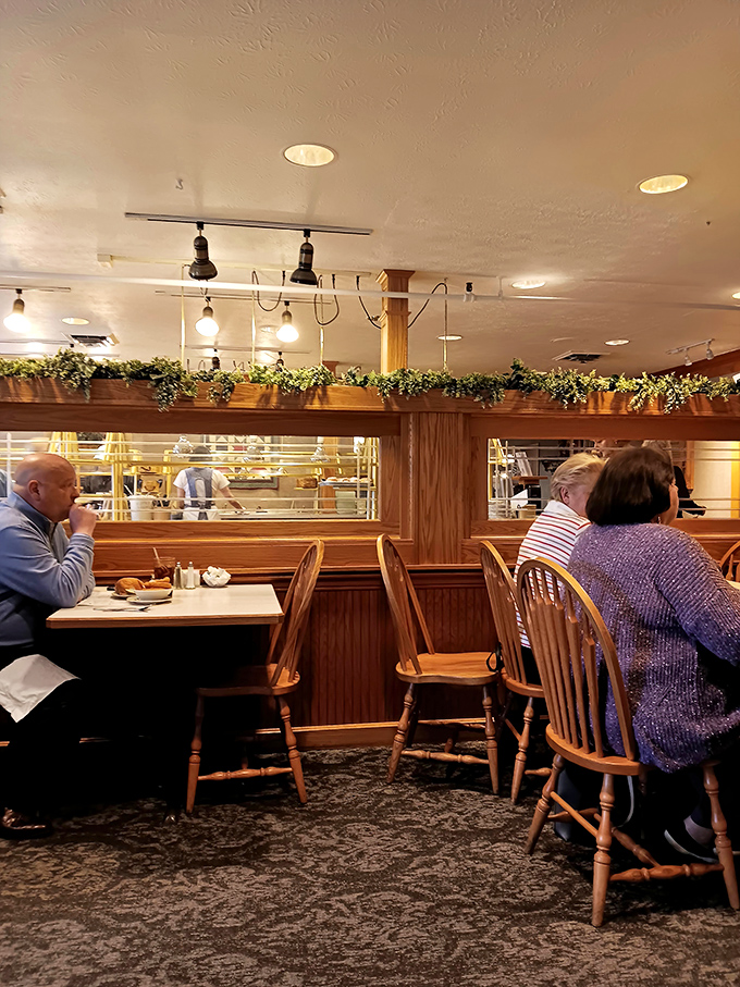 Diners enjoying the fruits of Amish Country cuisine. That wooden wainscoting has witnessed more food joy than a cooking show marathon.