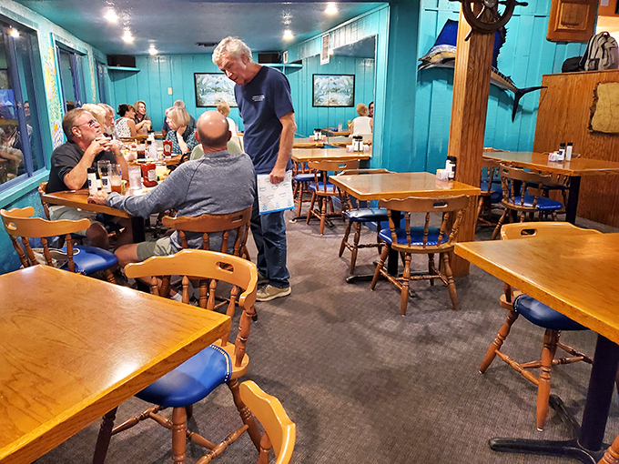 The true measure of a local spot: actual locals dining there. Blue walls and wooden tables create the backdrop for conversations that likely include fishing tales.