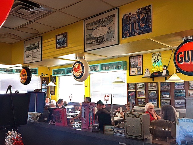 Where time stands still and conversation flows as freely as the coffee, under the watchful gaze of automotive legends immortalized on sunny yellow walls.