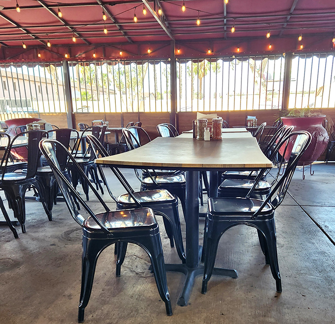 The covered patio area offers a more modern seating arrangement. String lights overhead add a touch of charm to this unpretentious eatery.