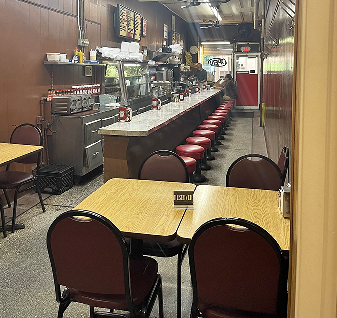 The full Duly's experience. Red stools at the counter, a few tables for groups, and that "RESERVED" sign that's seen more Detroit stories than most bartenders.