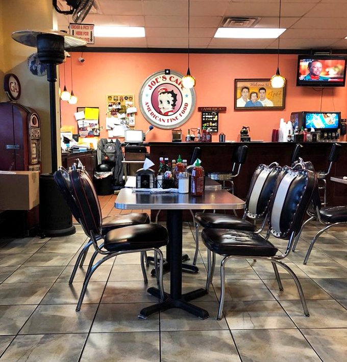 Amber pendant lights cast a warm glow over the dining area, where Betty Boop watches approvingly as generations gather around tables that have heard it all.