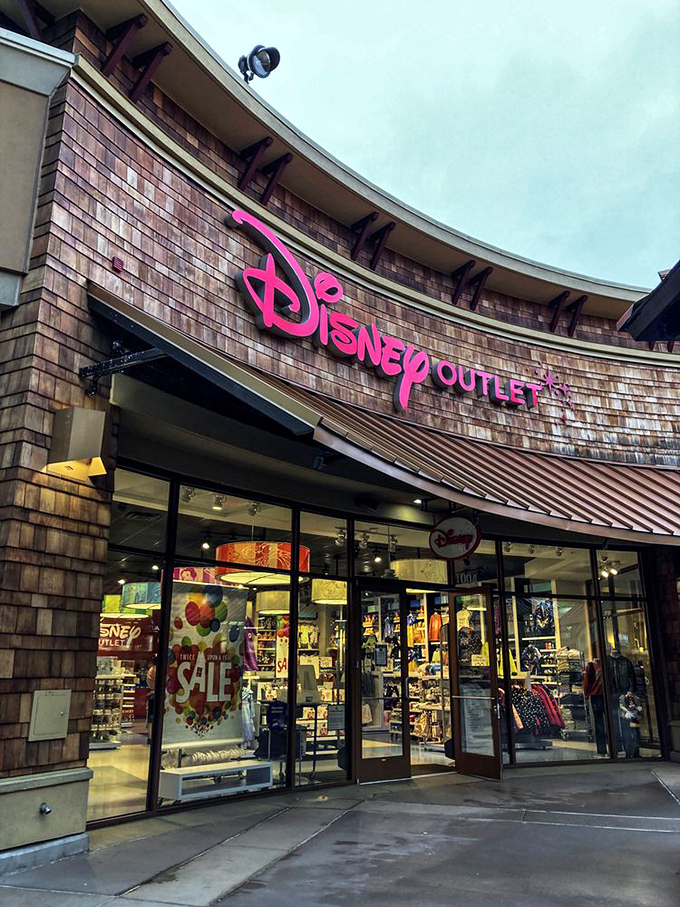 The Disney store's iconic pink sign glows like a beacon of childhood nostalgia, luring grandparents in to spoil grandchildren they won't see for weeks.