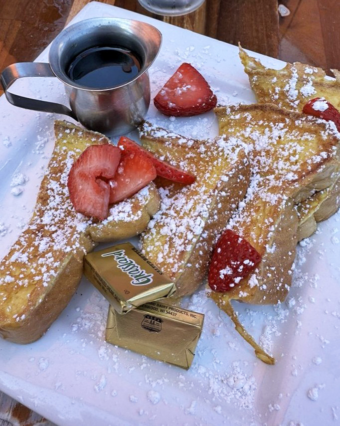 French toast that doesn't just break the fast&mdash;it demolishes it with golden custard-soaked bread and berries wearing powdered sugar like fresh snow.