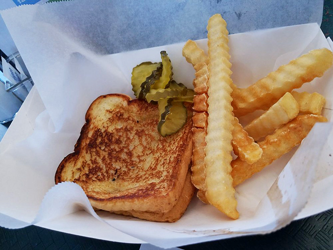 A grilled cheese sandwich with the perfect golden-brown crust that whispers, "Yes, they used real butter." Those pickles add just enough tang to cut the richness.