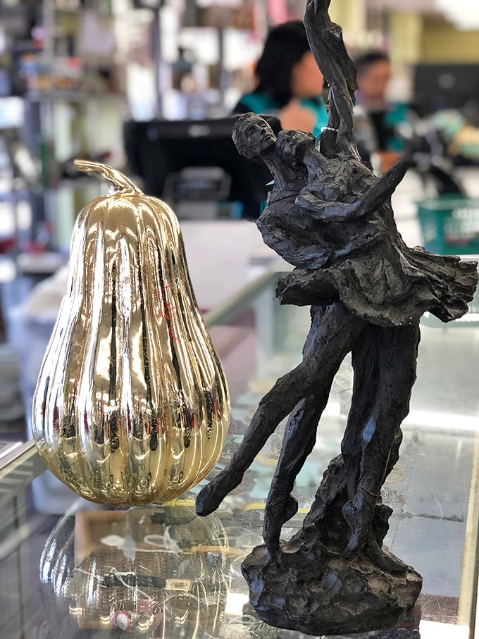 Art meets function in this display case, where a golden gourd and driftwood sculpture await the perfect eclectic living room.