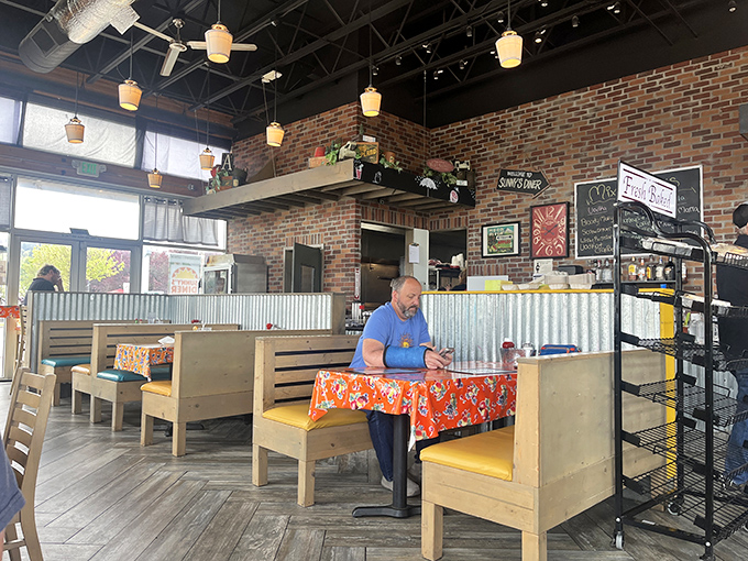 The exposed brick and yellow pendant lights create a warm glow that says, "Stay awhile, order dessert, life is good here."