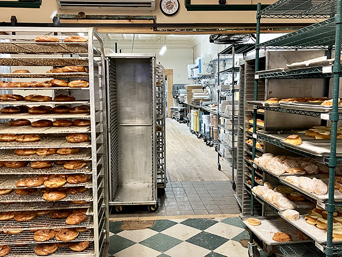 The kitchen corridor reveals the scale of operation—a donut assembly line where tradition trumps automation every time.