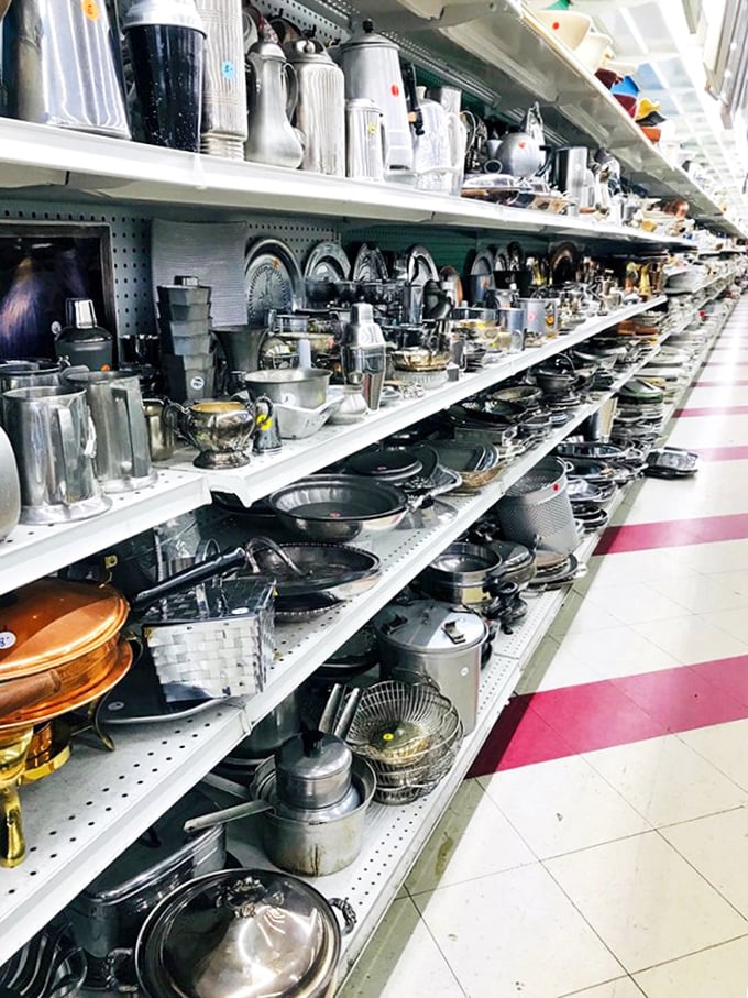 Kitchen utensil alley stretches toward infinity, a metallic timeline of America's cooking evolution. From forgotten gadgets to indestructible cast iron, culinary history lines these shelves.