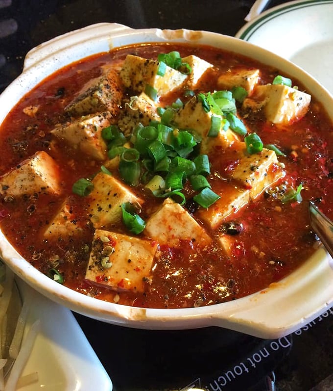 Mapo tofu that doesn't hold back on flavor &ndash; silken cubes swimming in a crimson sea of spicy sauce that tingles without overwhelming the palate.