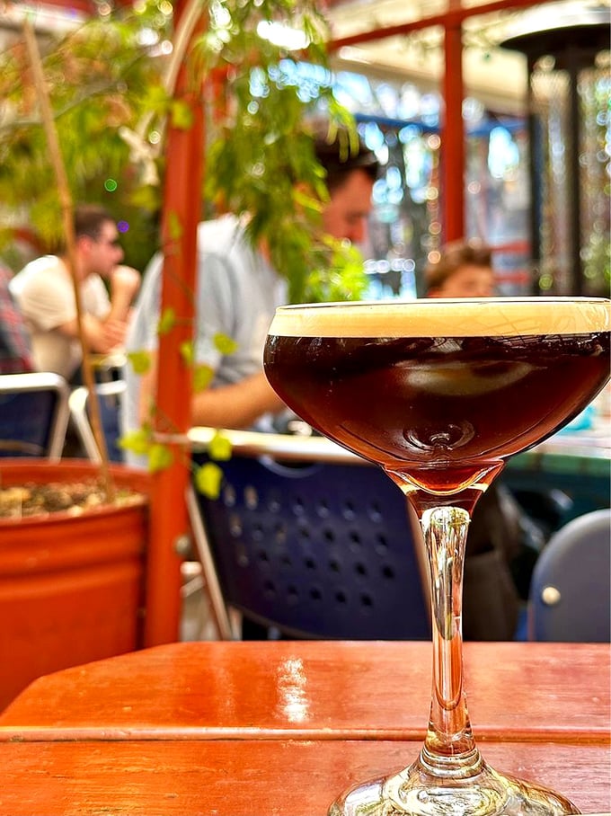 A cocktail that looks like it belongs in a film noir, sitting pretty in the dappled light of Silk City's enchanted garden.
