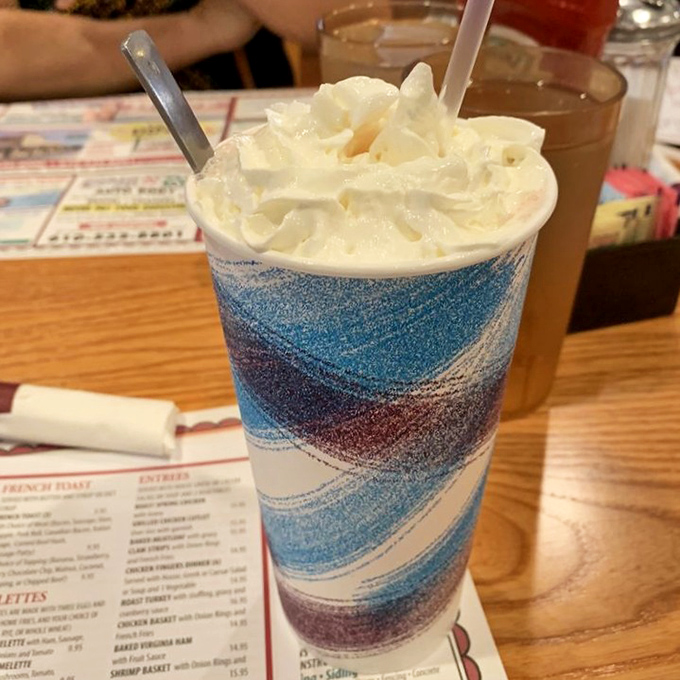 A proper diner milkshake: tall, colorful, and topped with enough whipped cream to make your inner child do a happy dance.