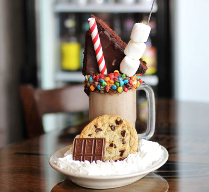 This isn't just a milkshake—it's dessert architecture, complete with structural support from cookies and a marshmallow skyline.