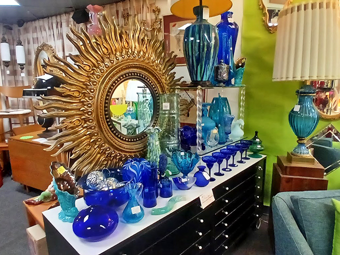 That sunburst mirror doesn't just reflect light&mdash;it radiates pure 1960s optimism alongside a sea of cobalt blue glassware that would make any collector swoon.