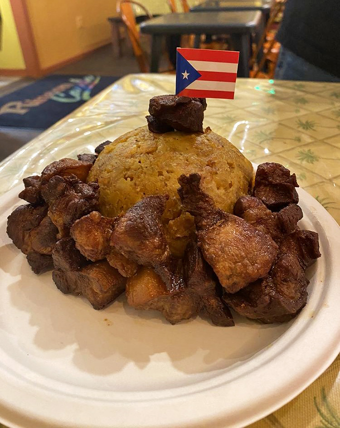 Mofongo crowned with a Puerto Rican flag&mdash;this mountain of mashed plantains and savory pork is a patriotic plate of pure comfort.