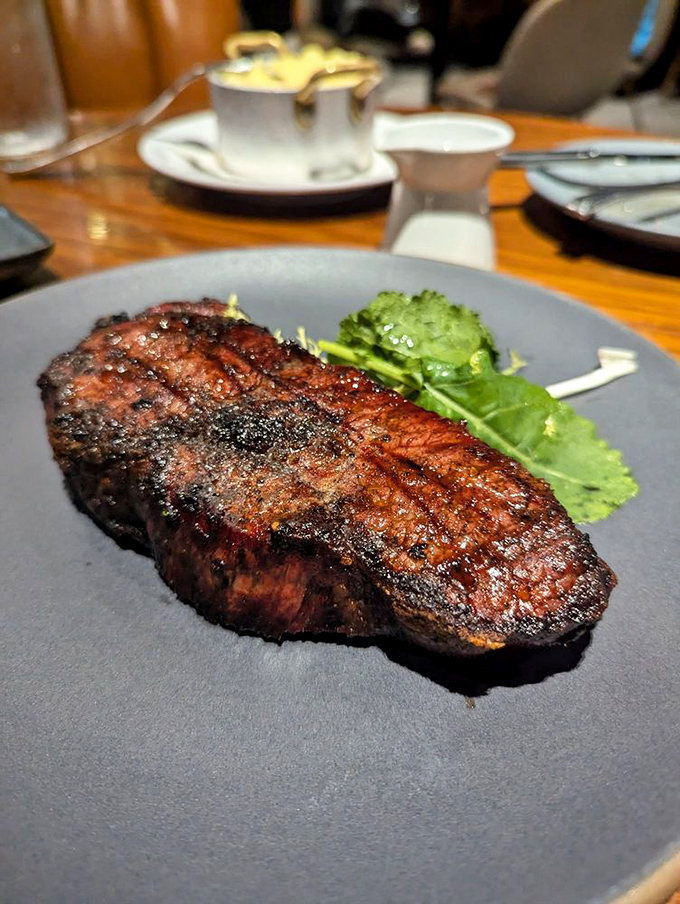 Minimalism at its finest—just a perfectly cooked NY Strip with greens that know their supporting role in this beef soliloquy.