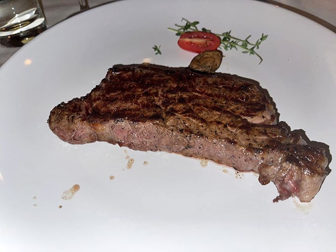 A perfectly cooked New York Strip with that textbook medium-rare center—the kind that makes you pause mid-conversation to savor the moment.