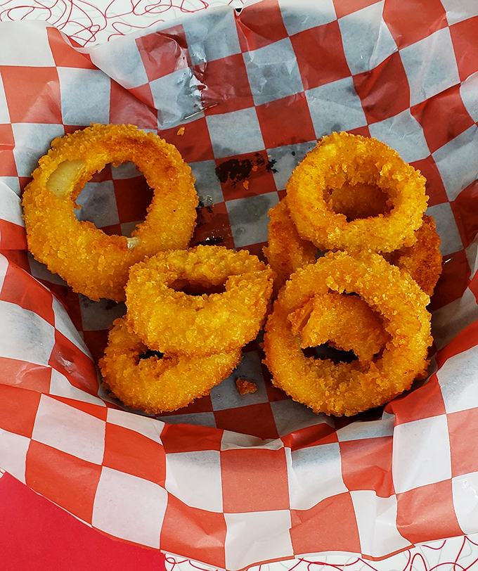 Onion rings stacked like golden halos, each one offering that perfect crunch-to-squish ratio that lesser diners spend decades trying to perfect.