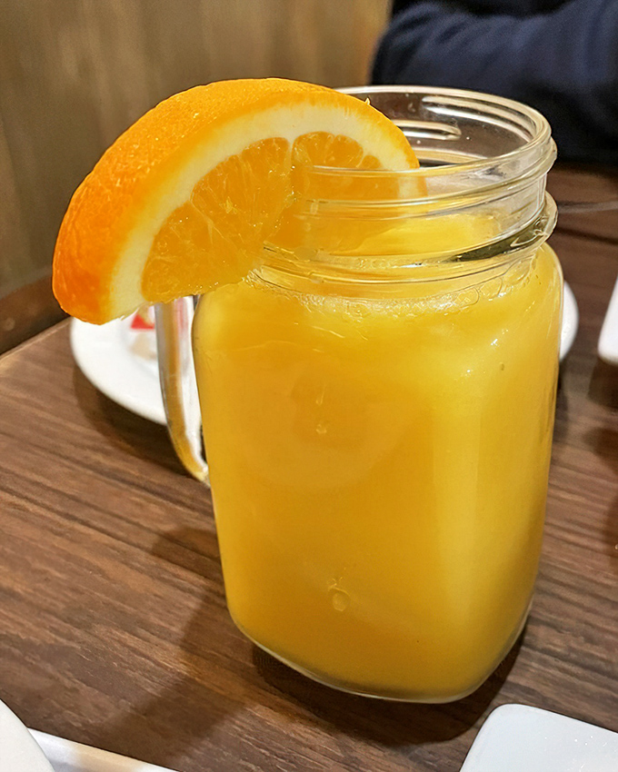 Fresh orange juice served in mason jars because sometimes simple presentation speaks loudest.