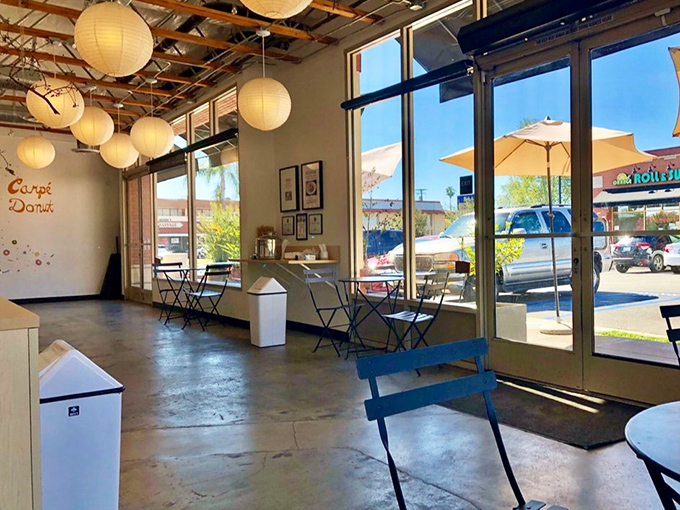 Sunlight streams through floor-to-ceiling windows, illuminating a space designed for donut contemplation. Even the seating invites you to linger a little longer.