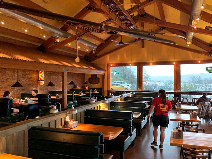 Booth seating with a view—where BBQ dreams and river scenes collide. Notice how nobody's looking at their phones? That's the power of good food.