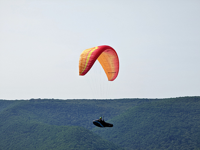 Flying without an engine, suspended between earth and sky. This paraglider dances with thermal currents in nature's ultimate freestyle performance.