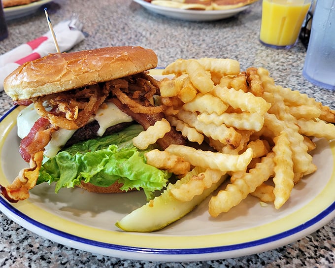 This isn't just a burger&mdash;it's an architectural masterpiece of beef, cheese, and toppings, with crispy fries standing guard like delicious sentinels.