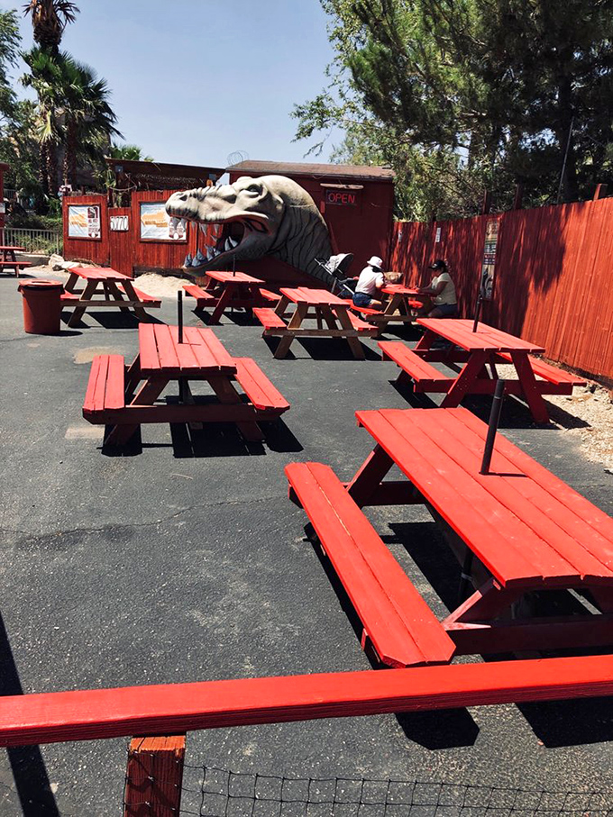 Red picnic tables provide the perfect spot for lunch while dinosaurs keep watch overhead.